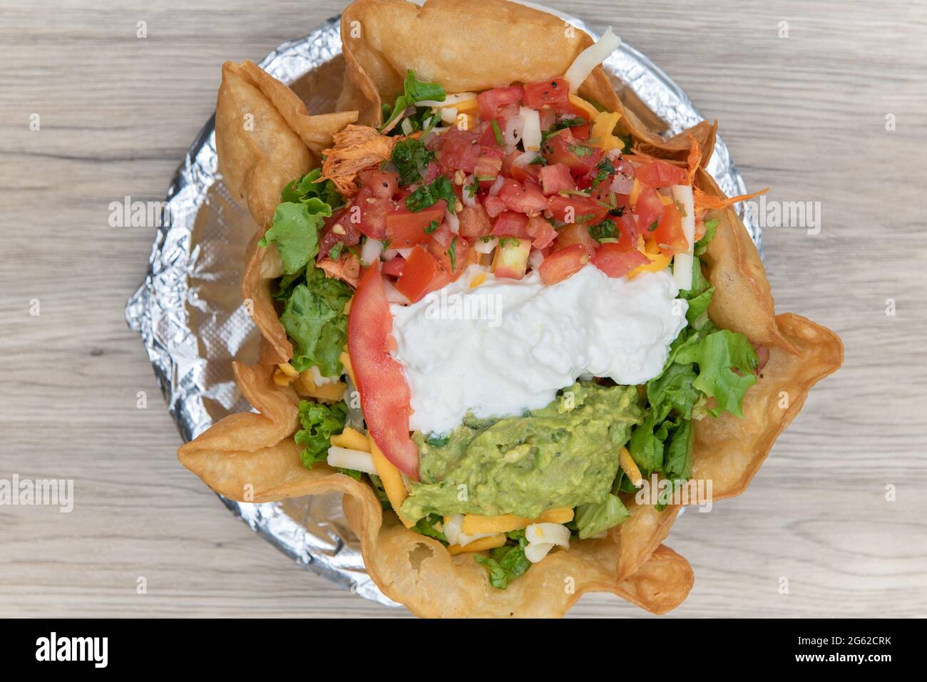 Overhead view of huge tostada crispy bowl filled completely and topped ...
