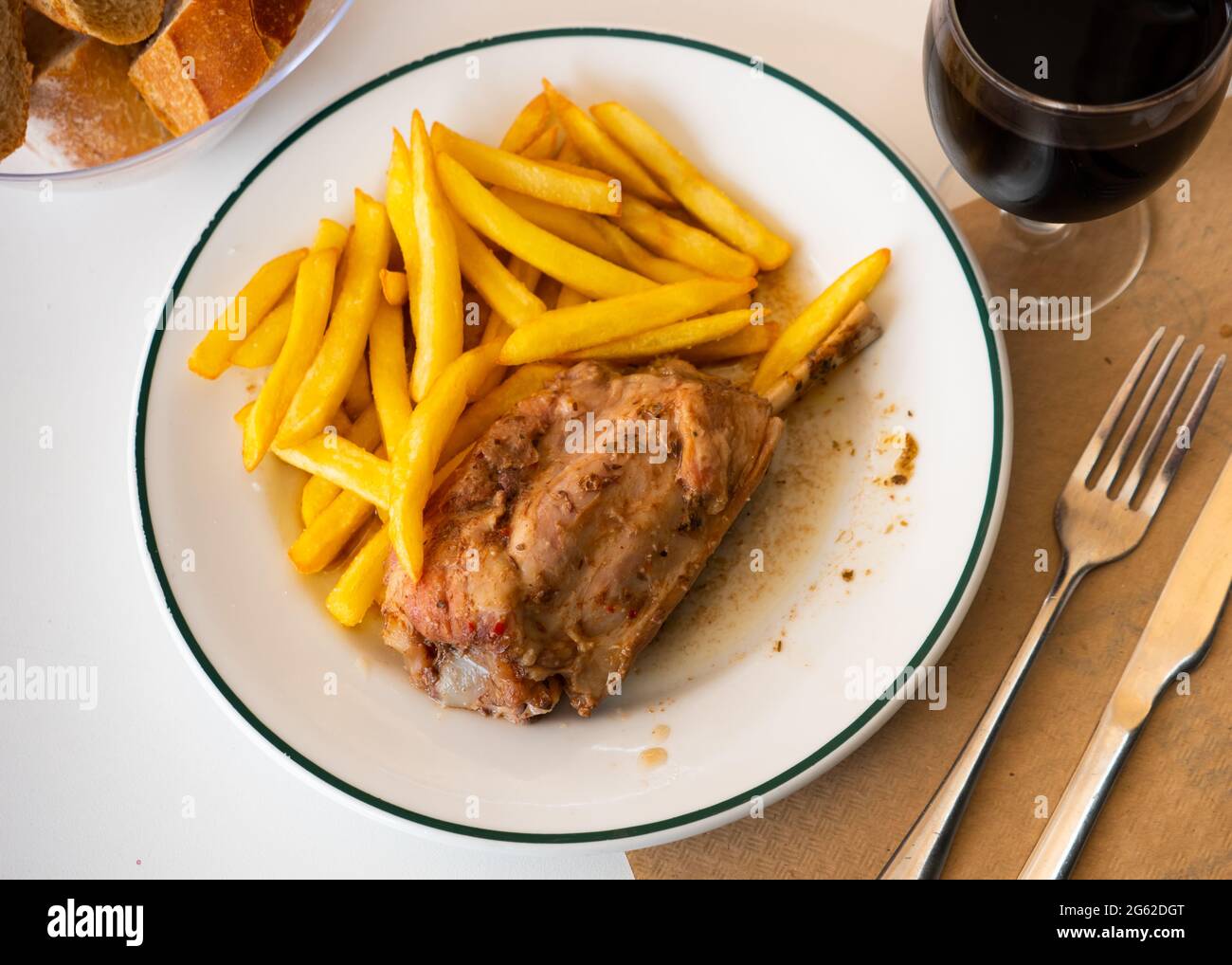 Braised pork knuckle with vegetable garnish of fries Stock Photo - Alamy