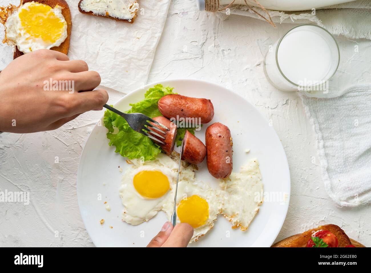 top view person eating breakfast on the white table, using tableware ...
