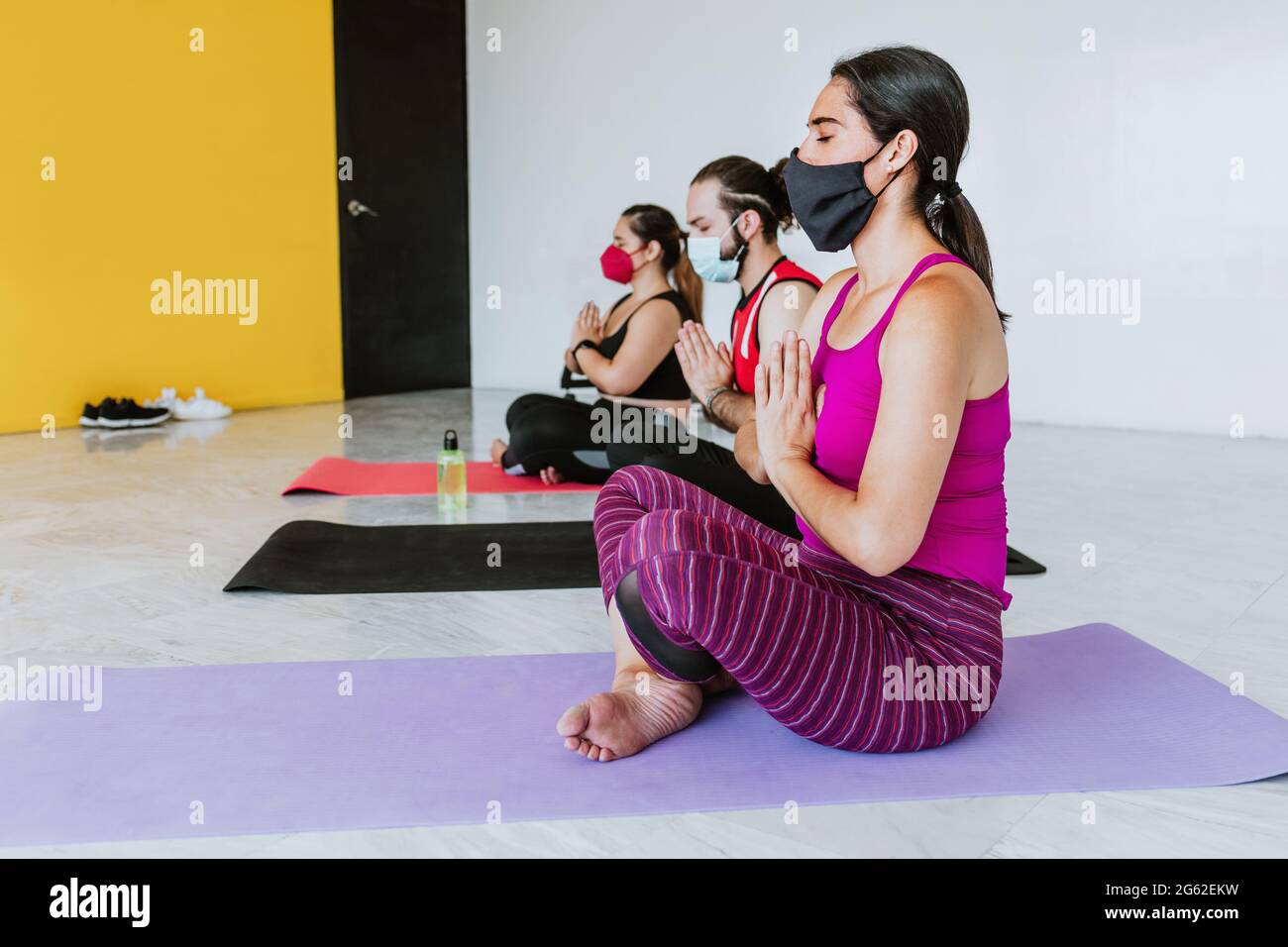 Latin people meditating in yoga wearing face masks during the pandemic ...