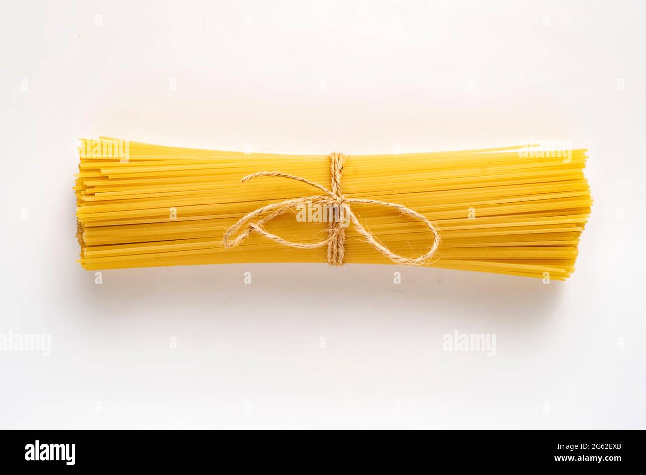 roped or tied bunch od dry uncooked spaghetti isolated on white surface ...