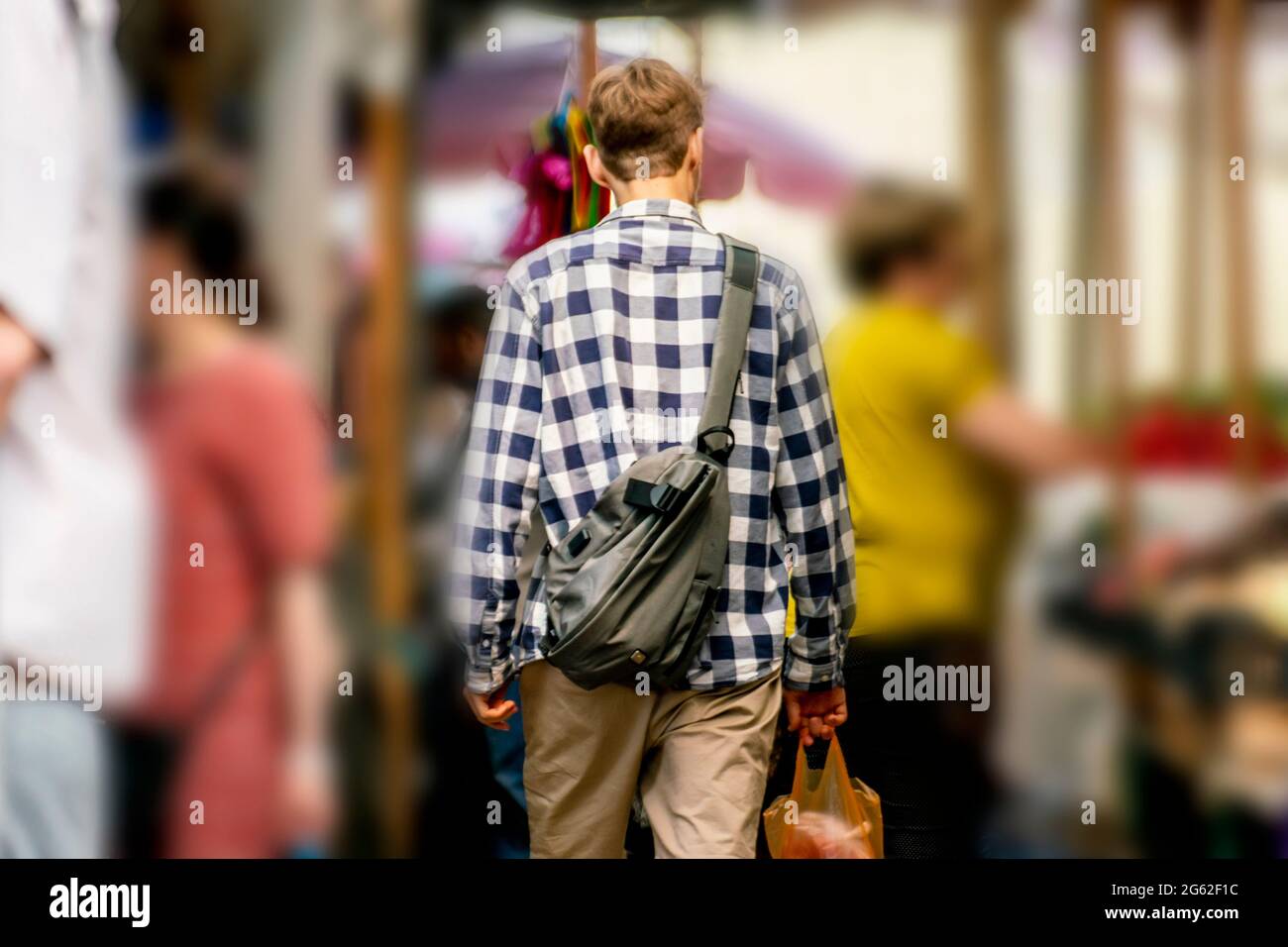 young person walking through the crowd at the city market Stock Photo ...