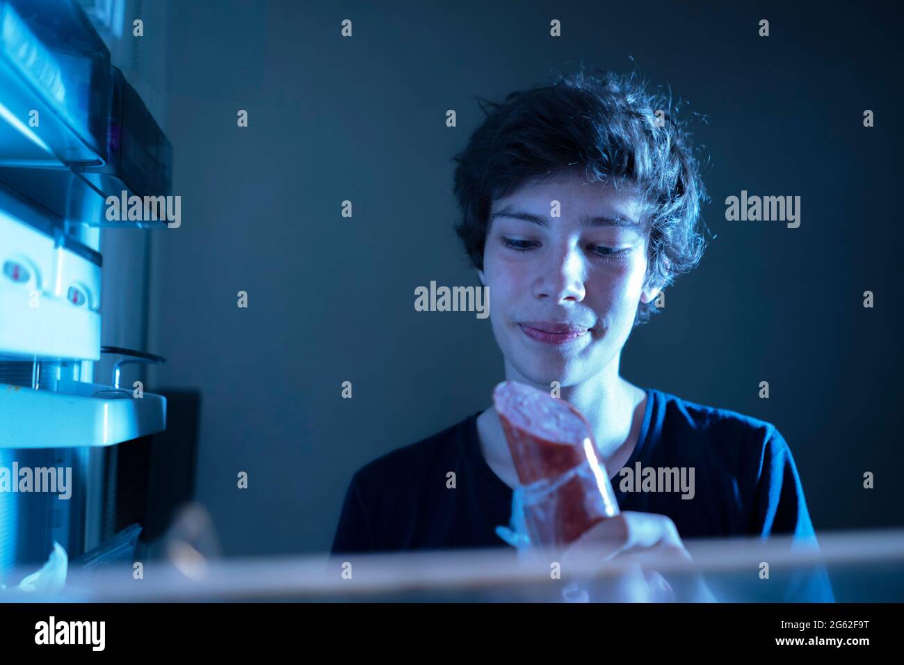 hungry man looking for a snack in the fridge at night, view from the ...