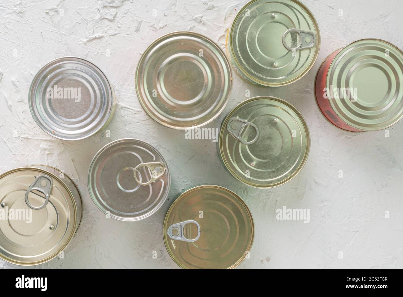 many unopened tin cans with meals such as meat and fish on the table ...