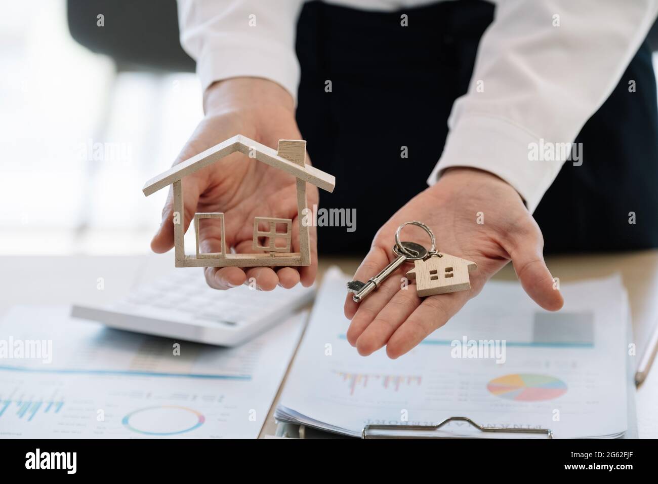 Real estate agent giving house key to the client after signing the real ...