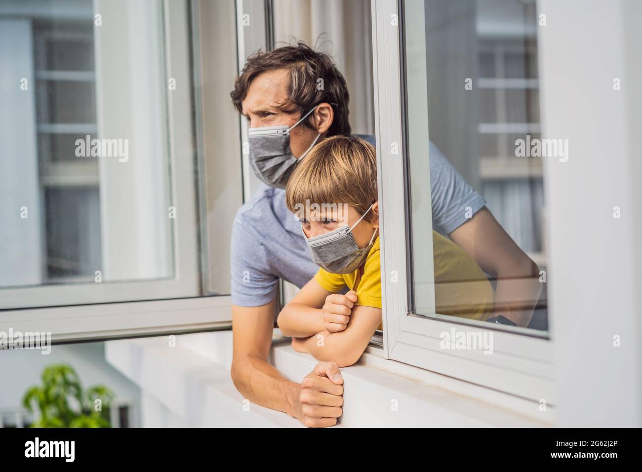 Extremly tired father and son looking out the window, home alone. self ...