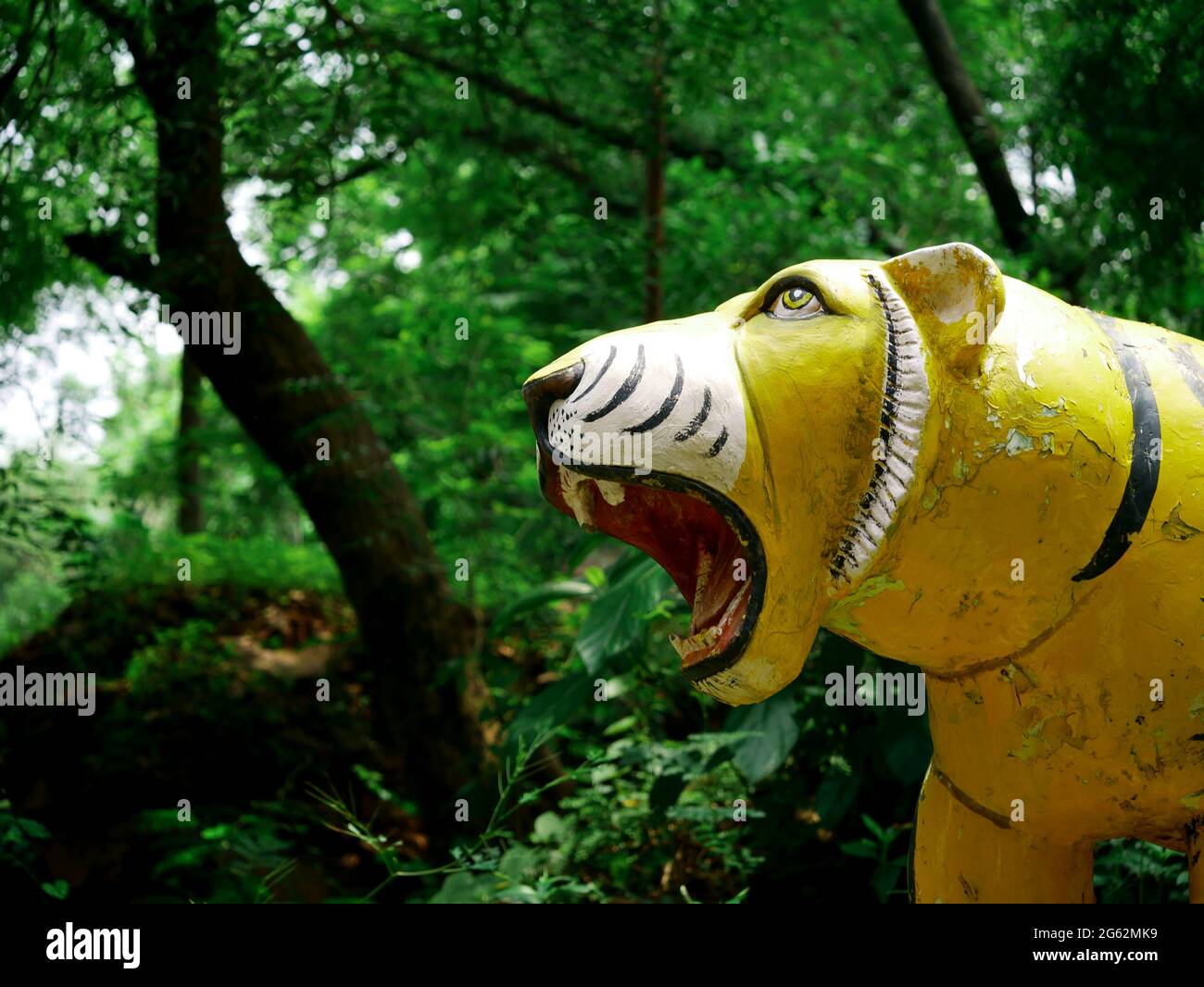 Lion statue in yellow color presented at green grass indian park field ...