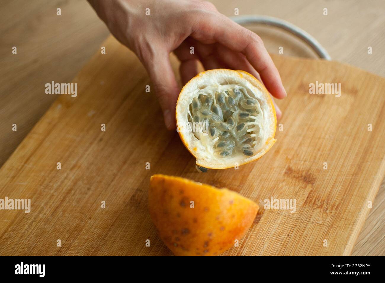 Fresh organic ripe granadilla or yellow passion fruit cut in half on a ...
