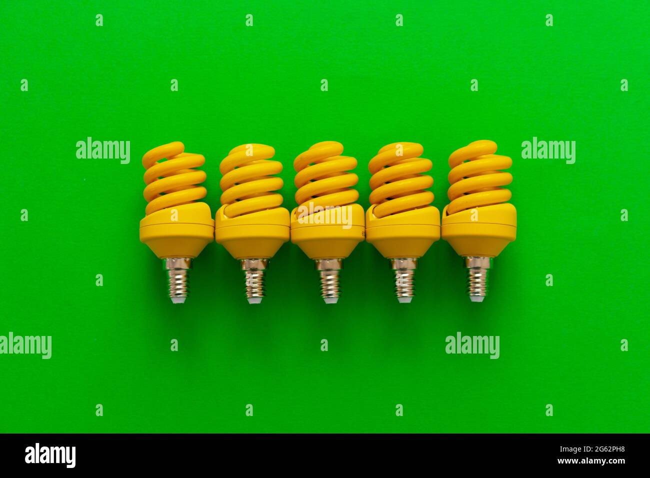 Light bulb on green paper background close up Stock Photo - Alamy