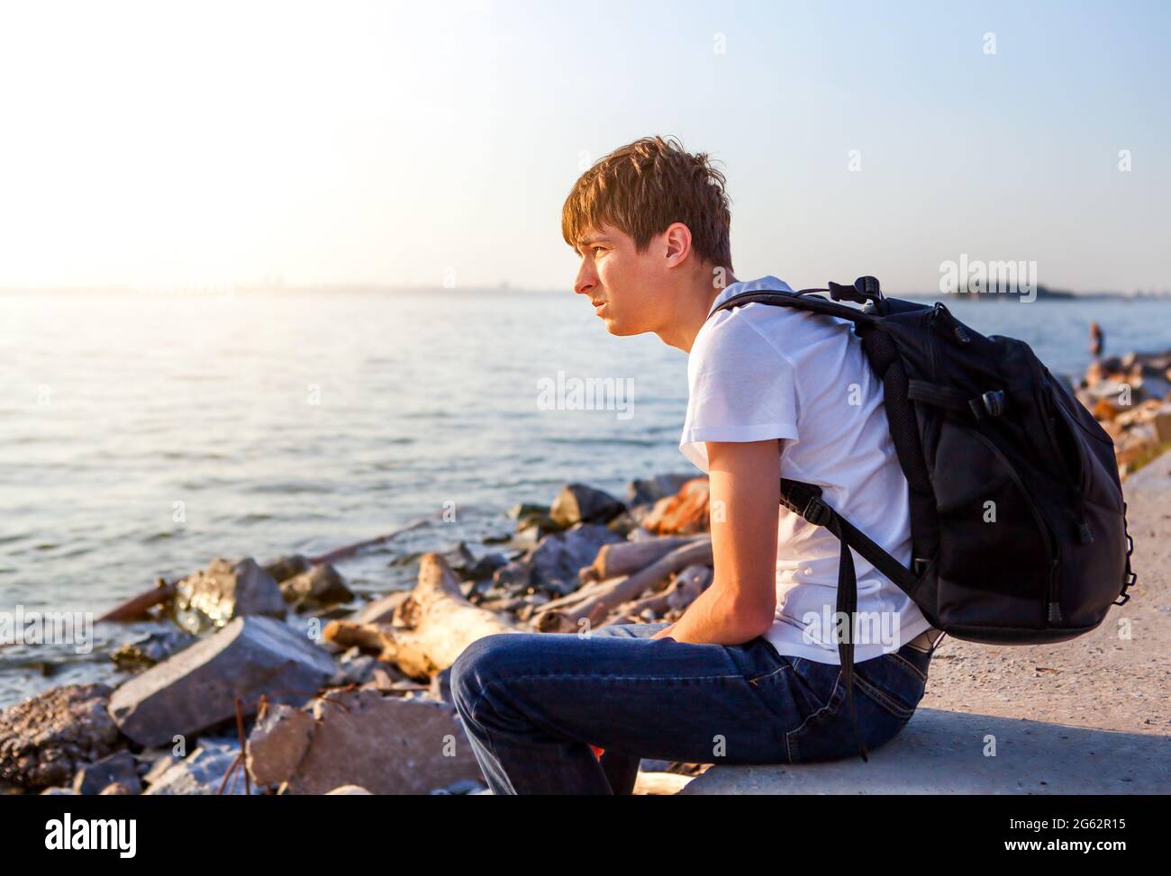 Sad Young Man with Backpack at the Seaside Stock Photo - Alamy