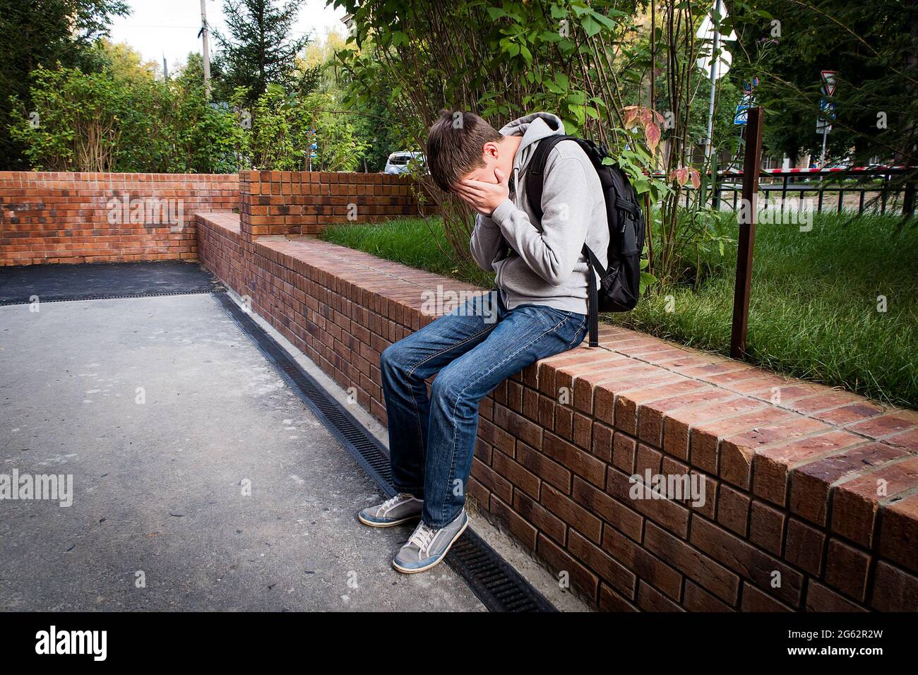 Sad Young Man sit on the City Street Stock Photo - Alamy