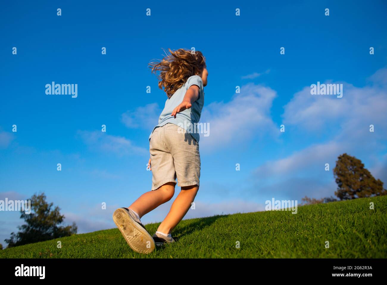 Child boy running on meadow. Happy kid run on beautiful summer field ...