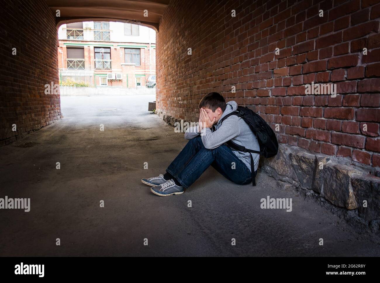 Sad Young Man sit on the City Street Stock Photo - Alamy
