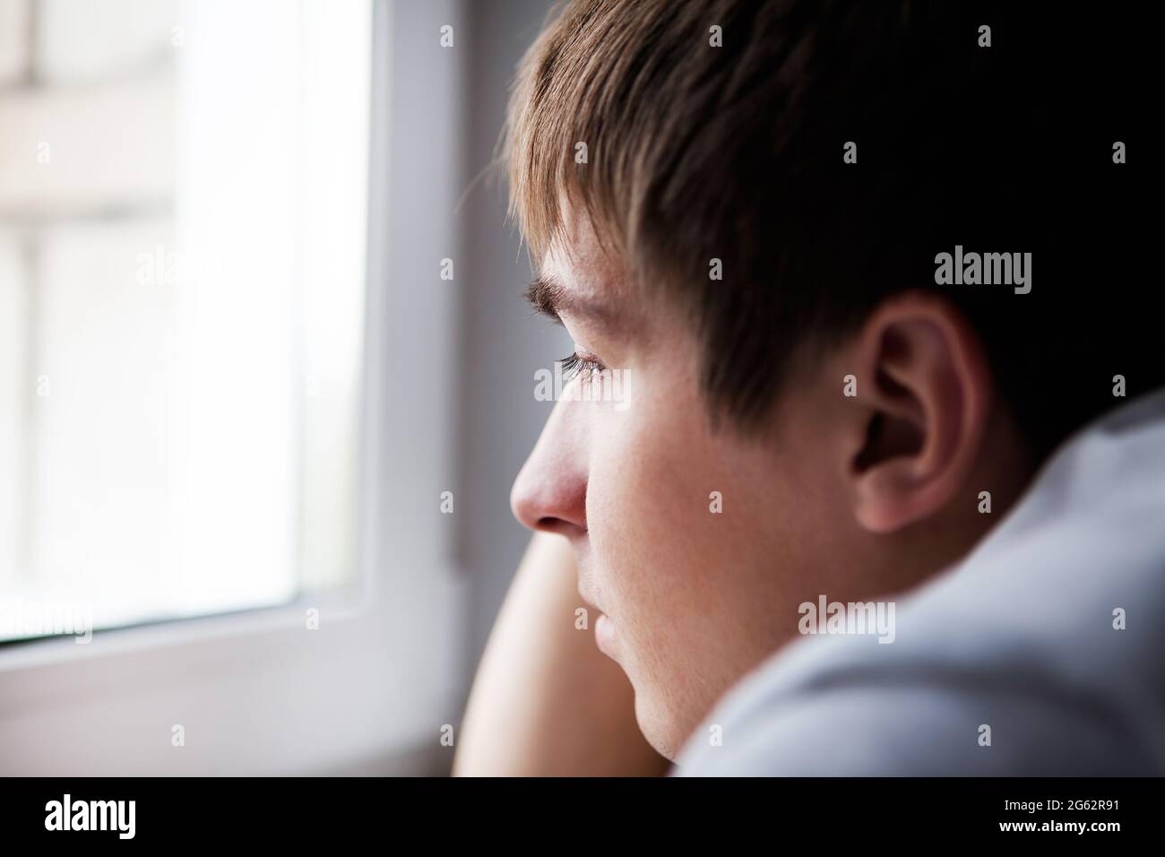 Sad Young Man by the Window in the Room Stock Photo - Alamy