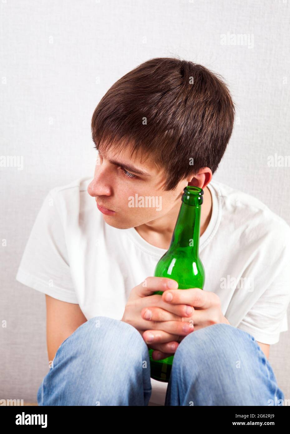 Sad Young Man with a Beer by the Wall Stock Photo - Alamy