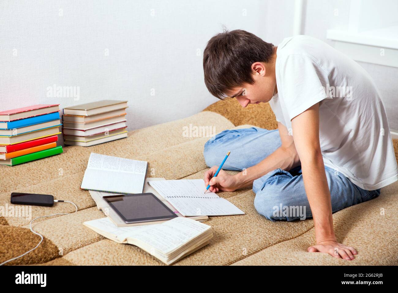 Young teenager doing homework textbook hi-res stock photography and ...