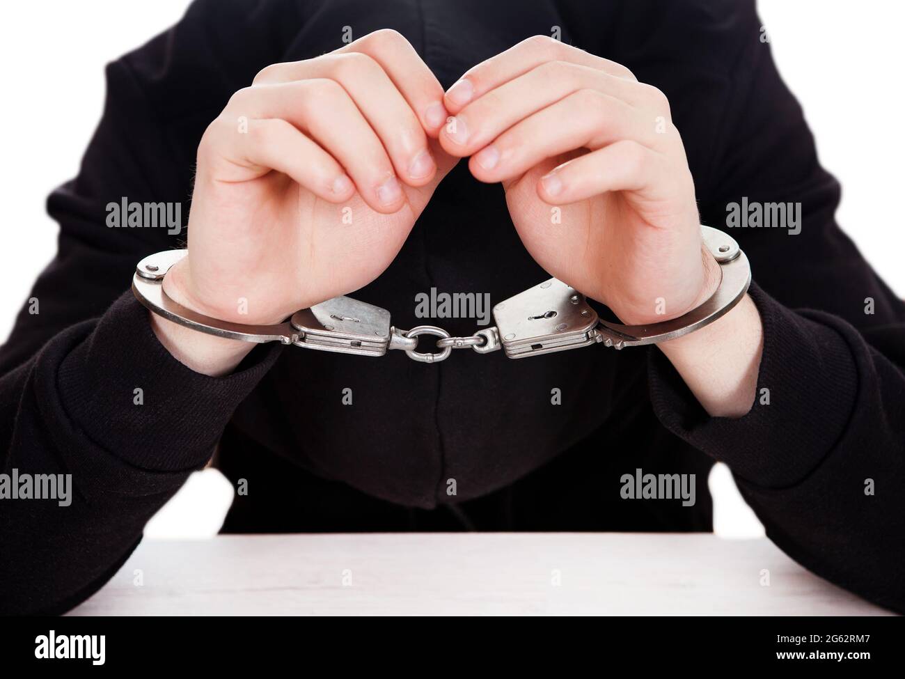 Person in Handcuffs on the Table closeup Stock Photo - Alamy