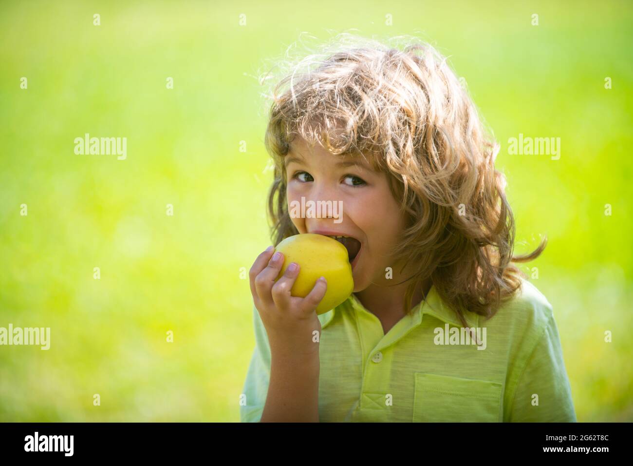 Little cute child eating green apple. Portrait of kid eating and biting ...