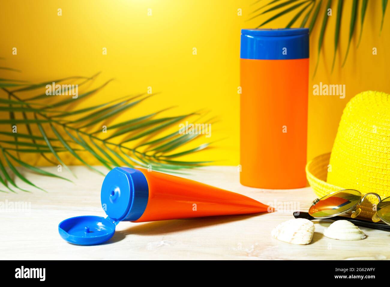 Tubes with mock up sunscreens on the table with yellow summer ...
