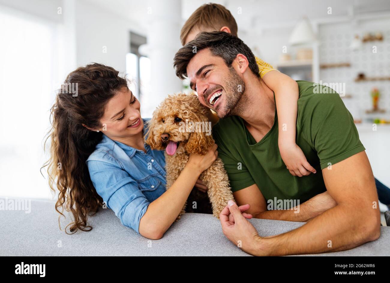 Happy family having fun time, playing together at home with dog Stock ...
