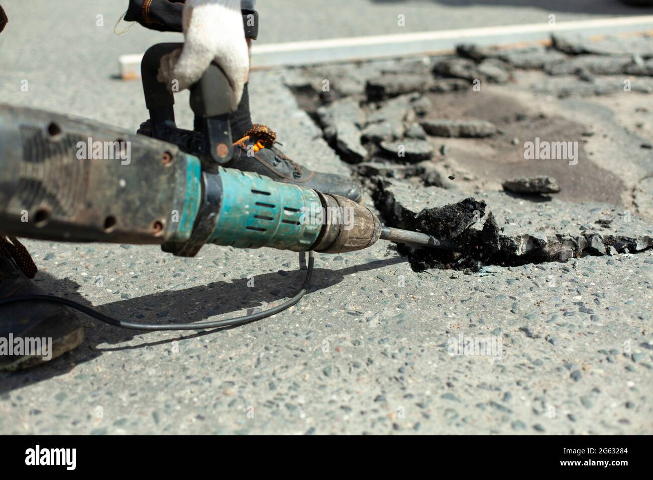 He removes the asphalt with a jackhammer. Removing the asphalt layer ...