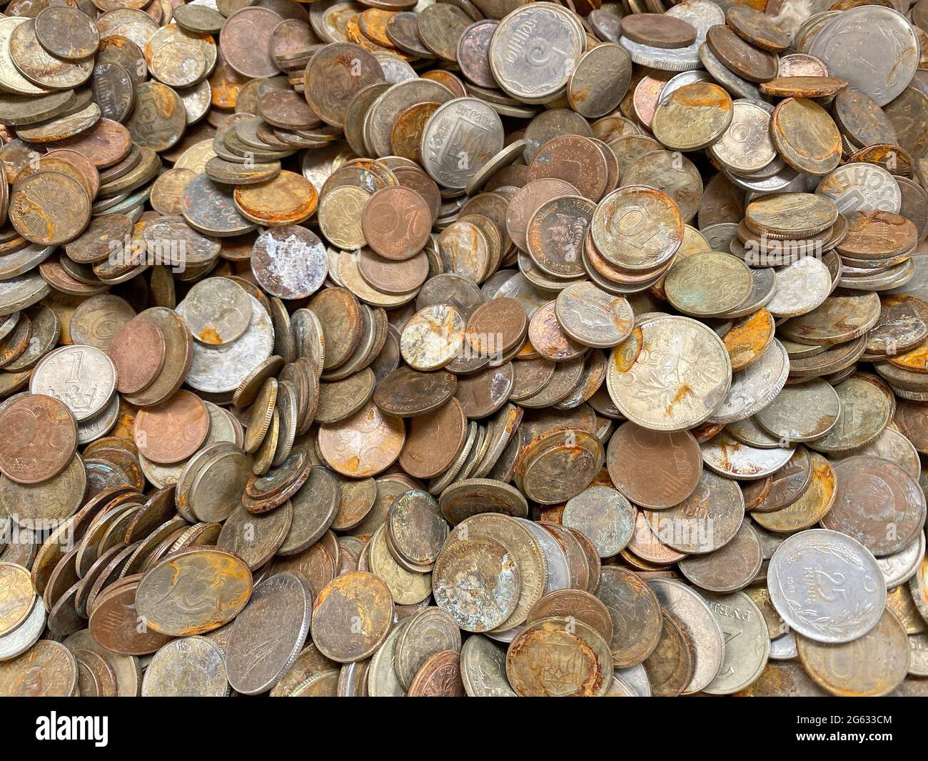 Top view many rusted coins of different nominal values heaped in light ...