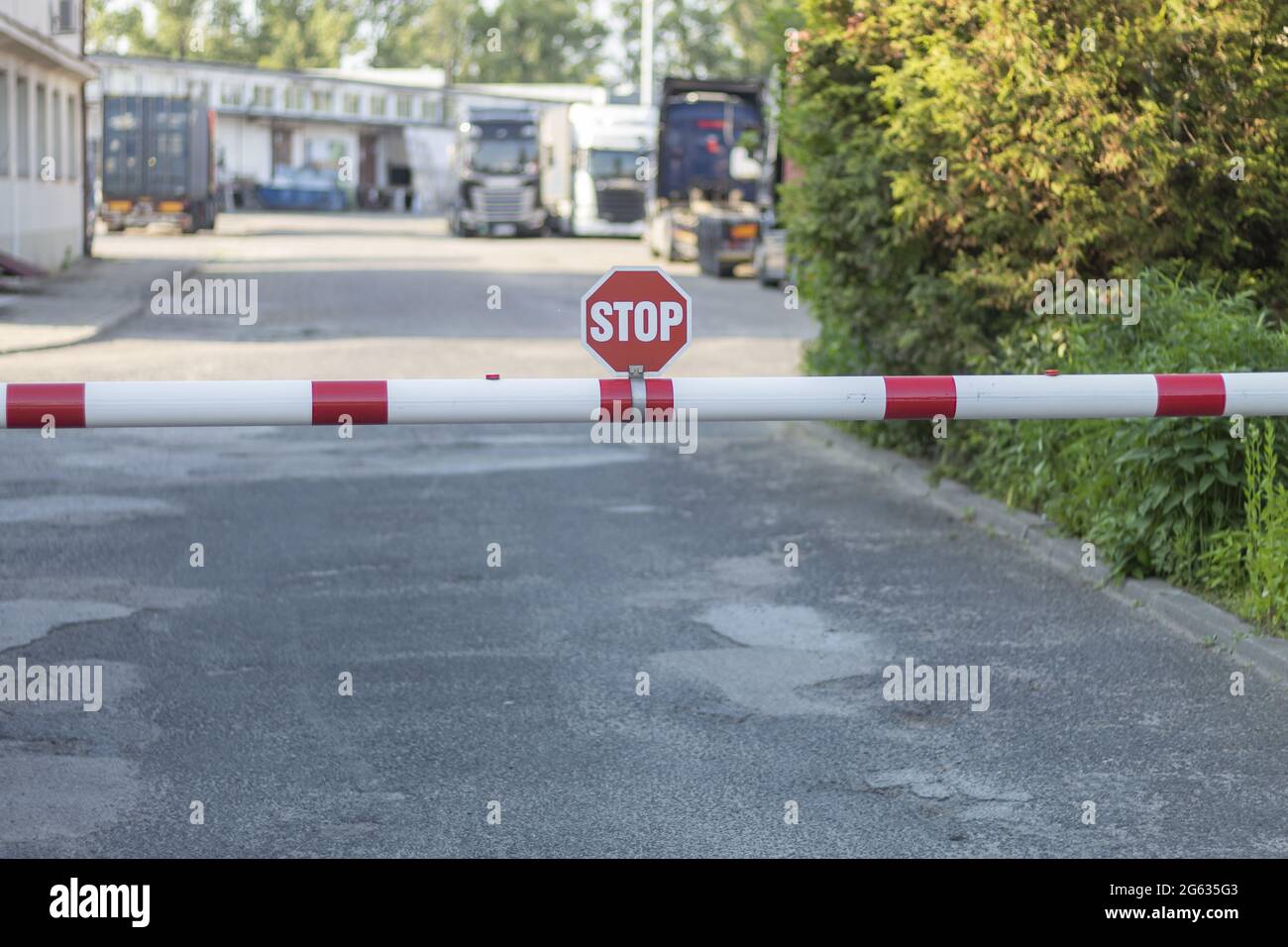 Barrier and stop sign on the road. Entrance to organization gate ...