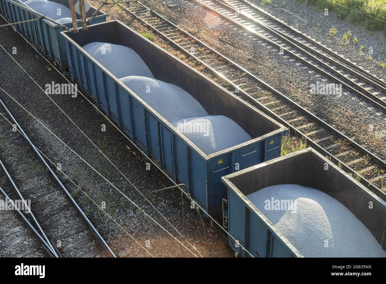 Loaded railway carriages travel on rails. Freight train with white ...
