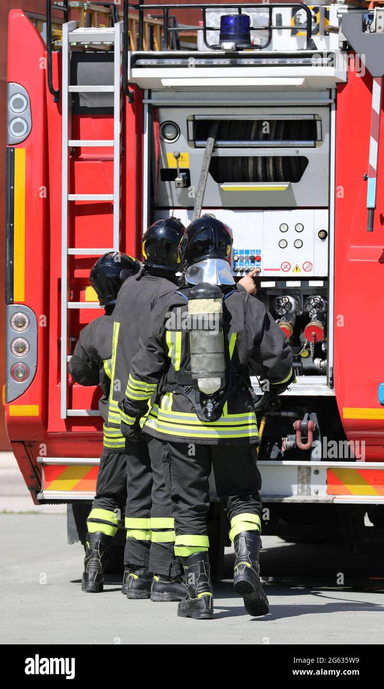 Teamwork of firefighters and the red firetruck during the emergency ...