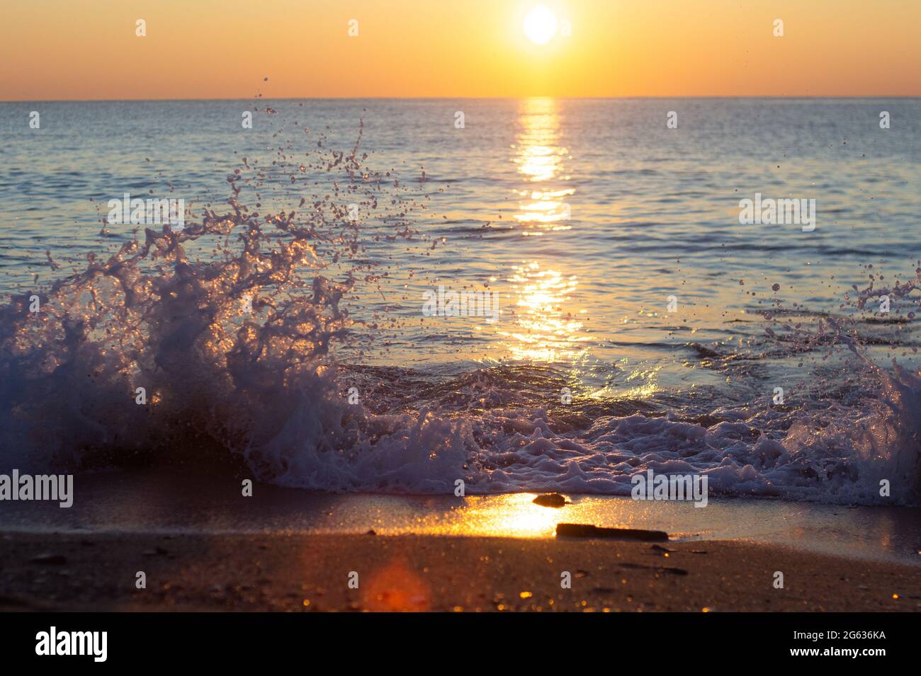 Waves through the rising sun Stock Photo - Alamy