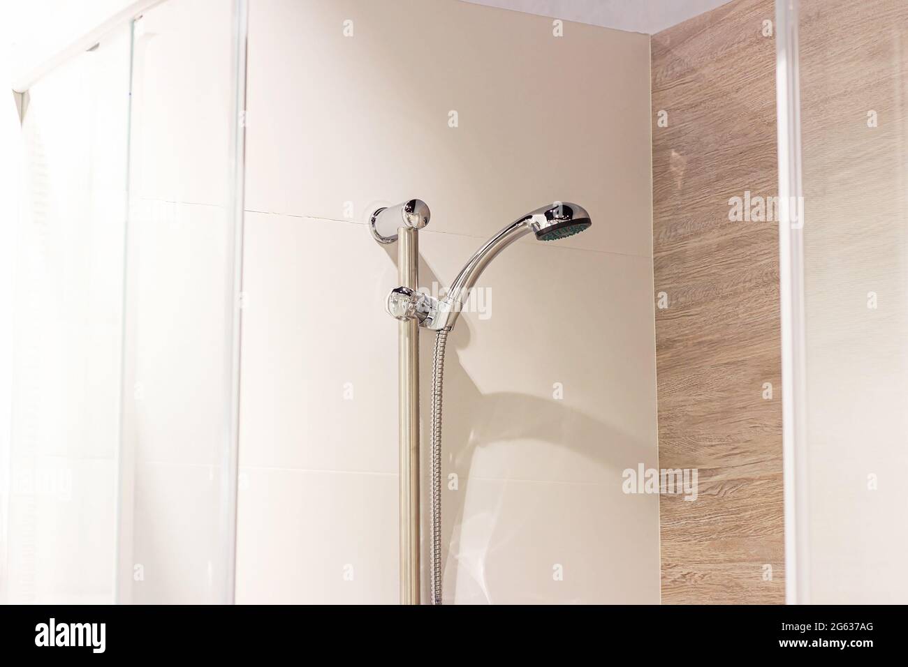 New shiny metal shower head on ceramic tile wall background in the ...