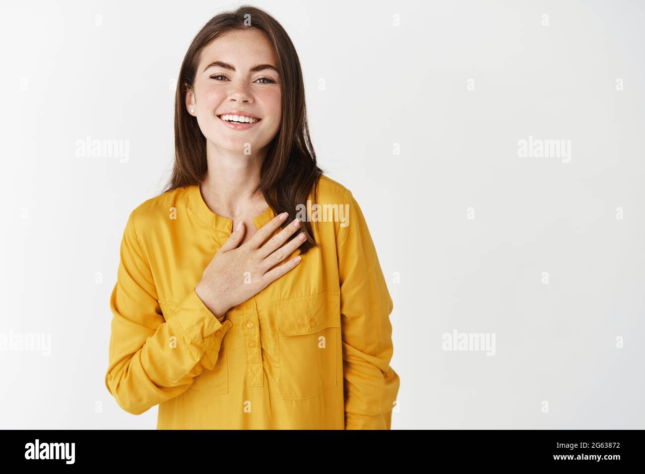Young happy woman saying thank you, holding hand on heart and smiling ...
