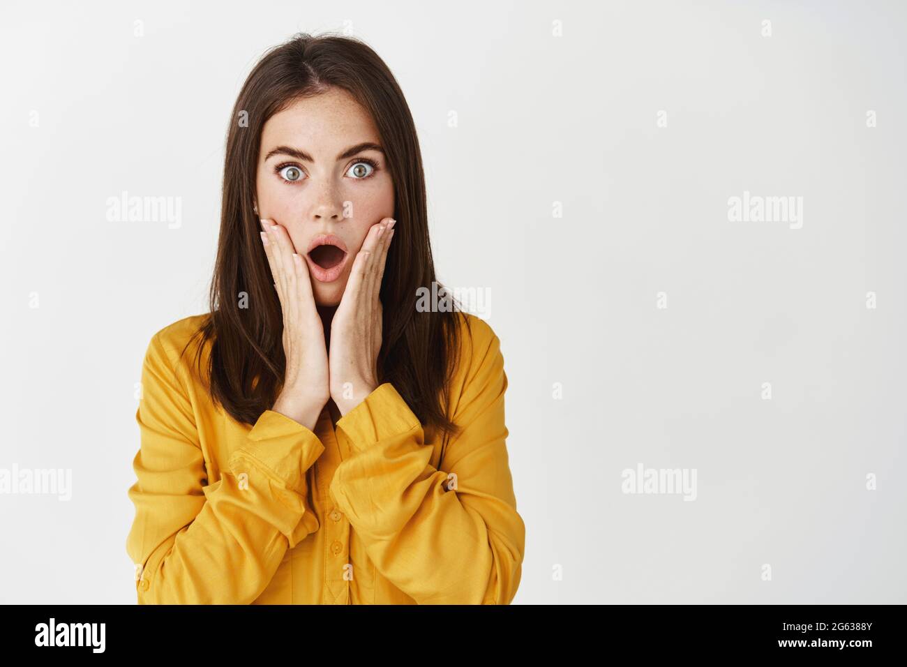 Young woman receive shocking bad news, staring at camera startled ...