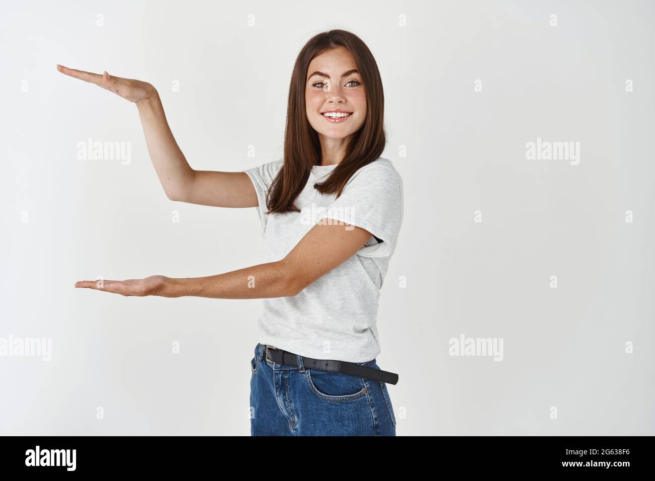 Young cheerful woman demonstrate large sign or banner, shaping big size ...