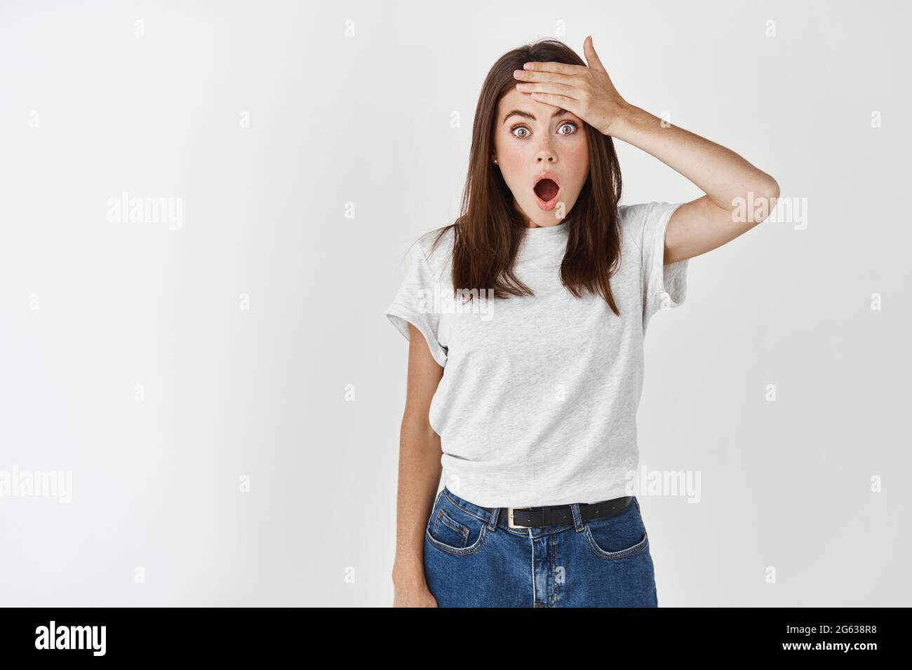 Young woman with surprised face staring at camera, drop jaw and slap ...