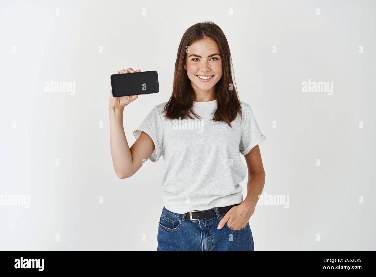 Young beauty woman holding blank screen mobile phone and smiling ...