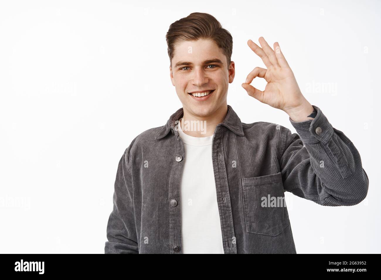 Zero no problems. Smiling young man shows okay OK sign, looks confident ...