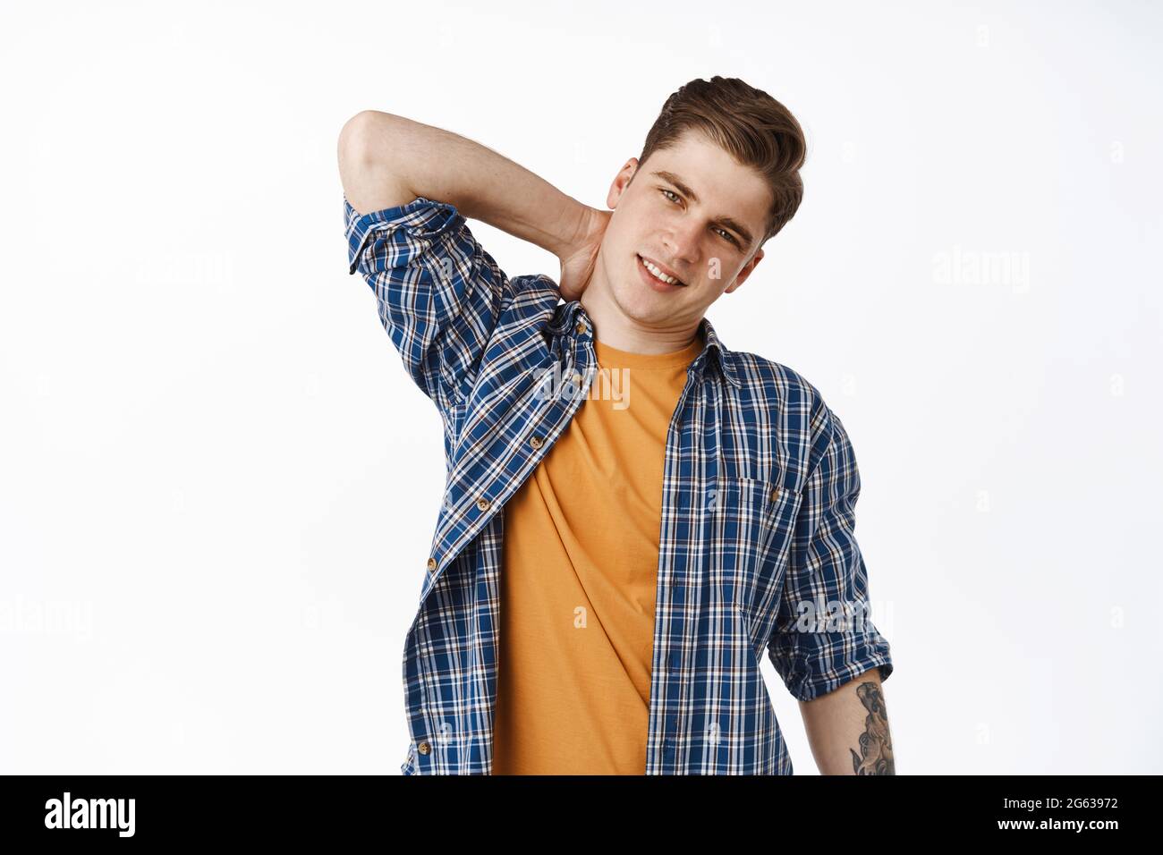Portrait of reluctant young man, boy touching neck back and look ...