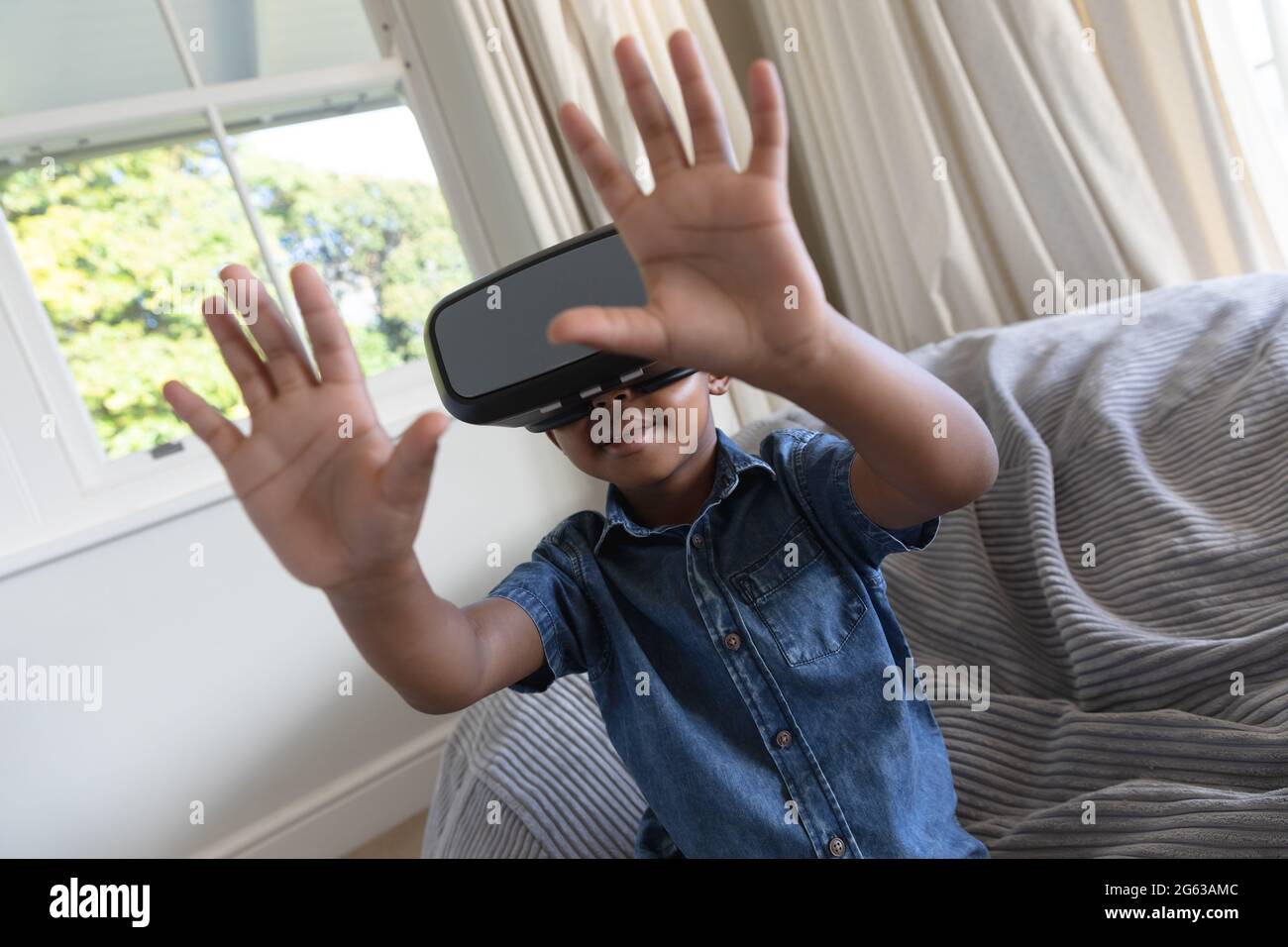 Happy african american boy using vr headset and smiling at home Stock ...