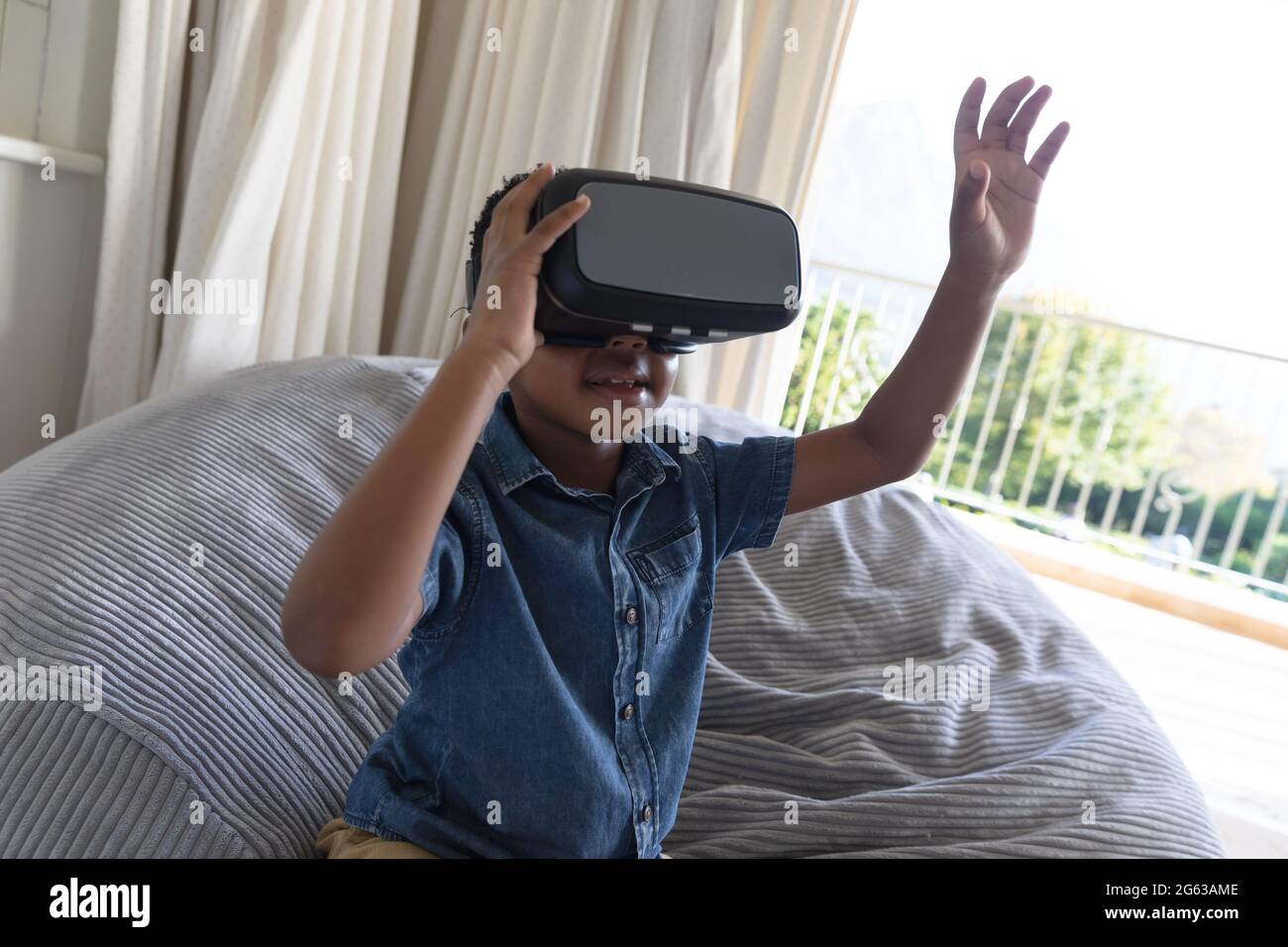 Happy african american boy using vr headset and smiling at home Stock ...