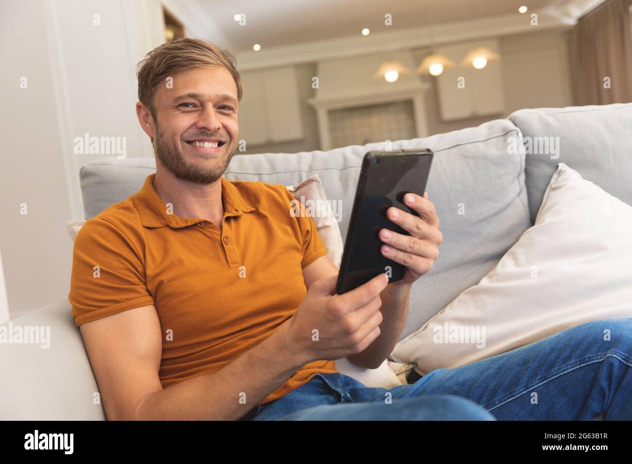 Man sitting couch smiling hi-res stock photography and images - Alamy