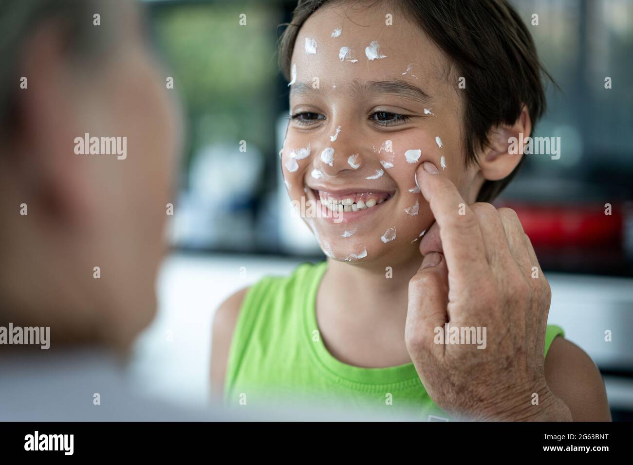Grandmother and little boy putting cream protection on their face Stock ...