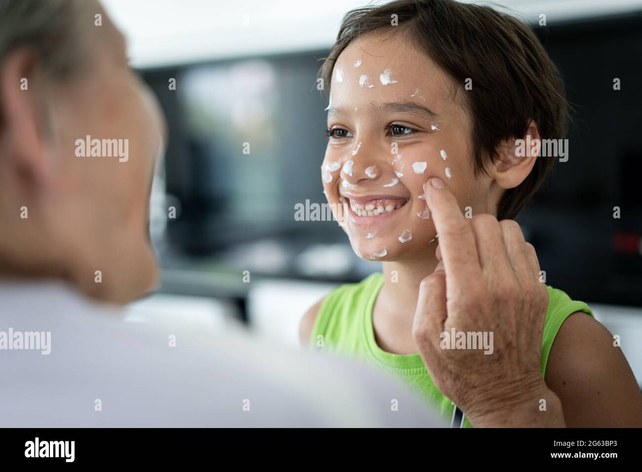 Grandmother and little boy putting cream protection on their face Stock ...