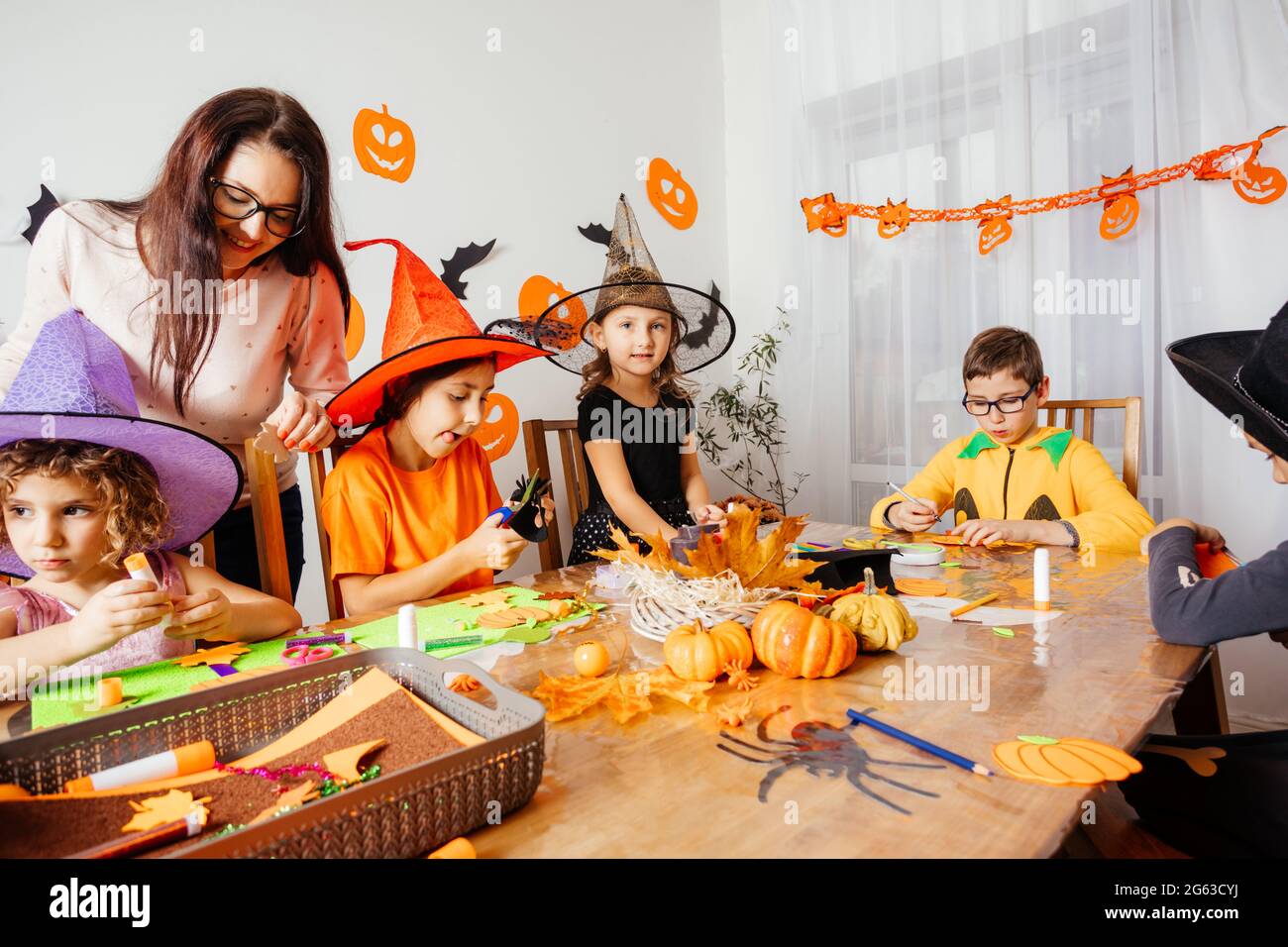 Teacher helping creative children to make paper bookmarks Stock Photo ...
