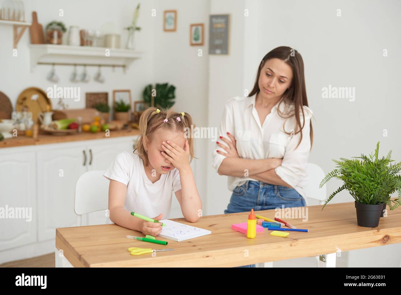Young girl doing homework during extra-curricular classes with a tutor ...