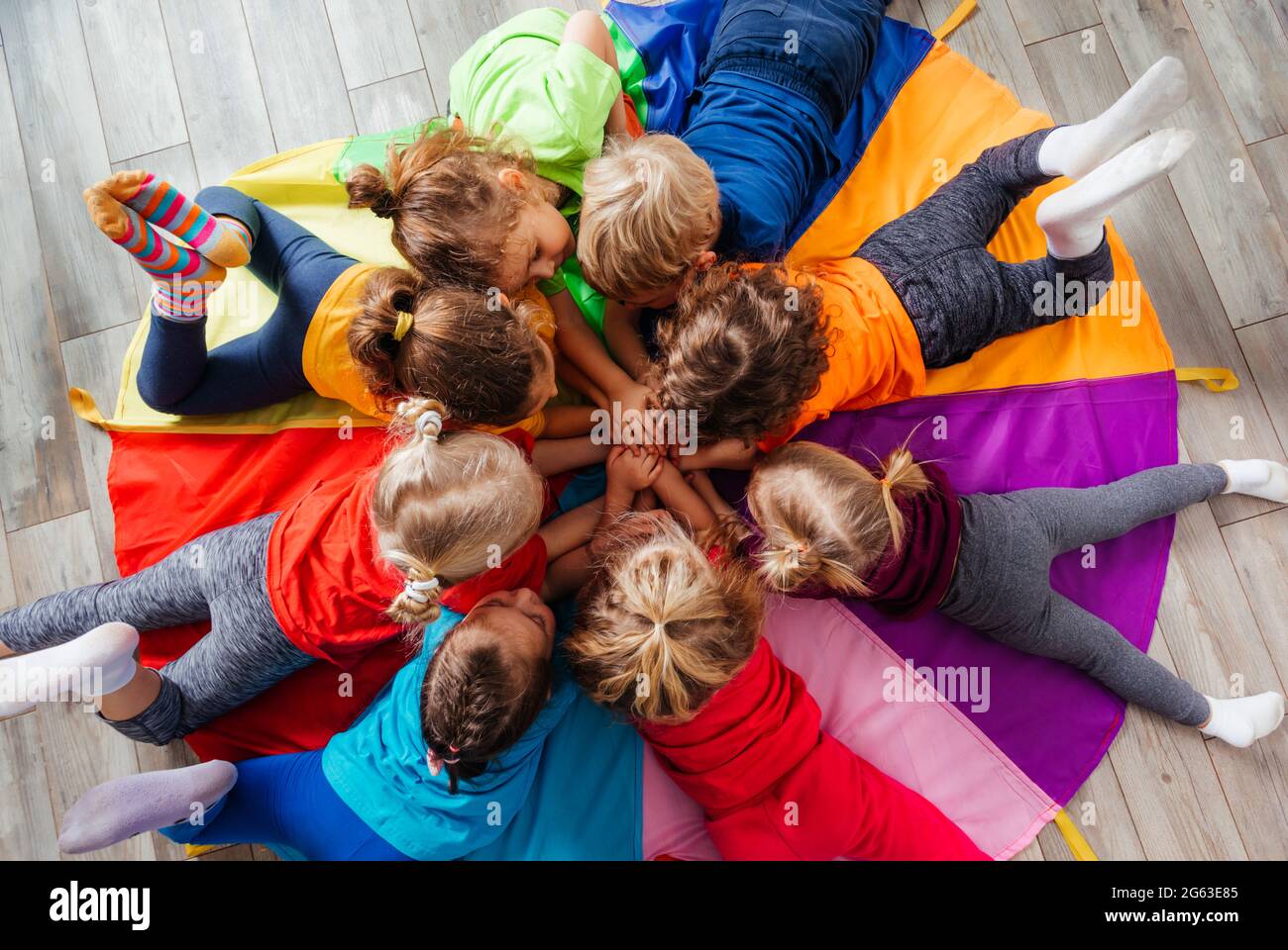 Cheerful children playing team building games on a floor Stock Photo ...