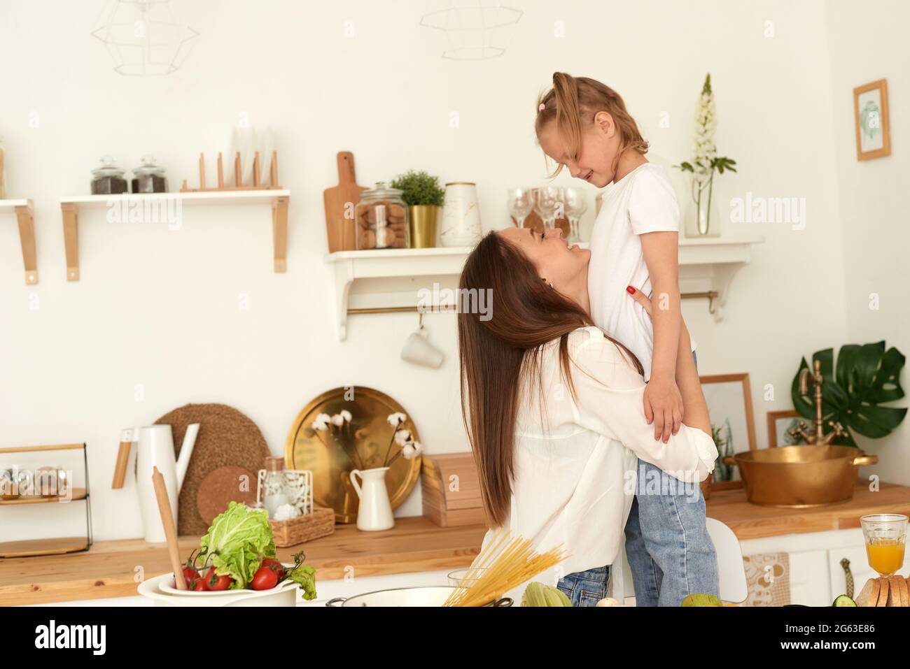 Happy family healthy life concept. Mom hugs her daughter in the kitchen ...