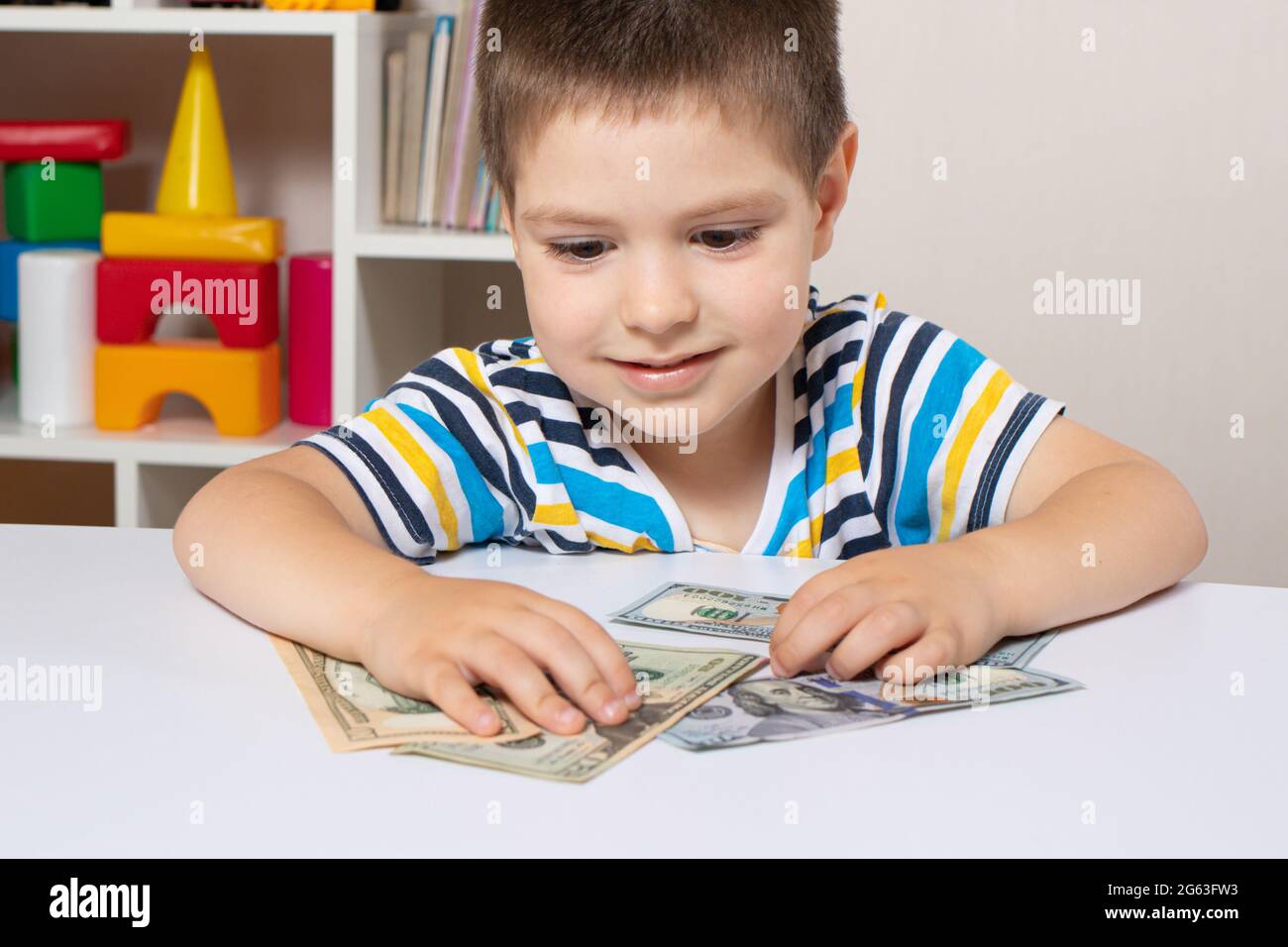A 4-year-old child learns to count money. Financial literacy and ...