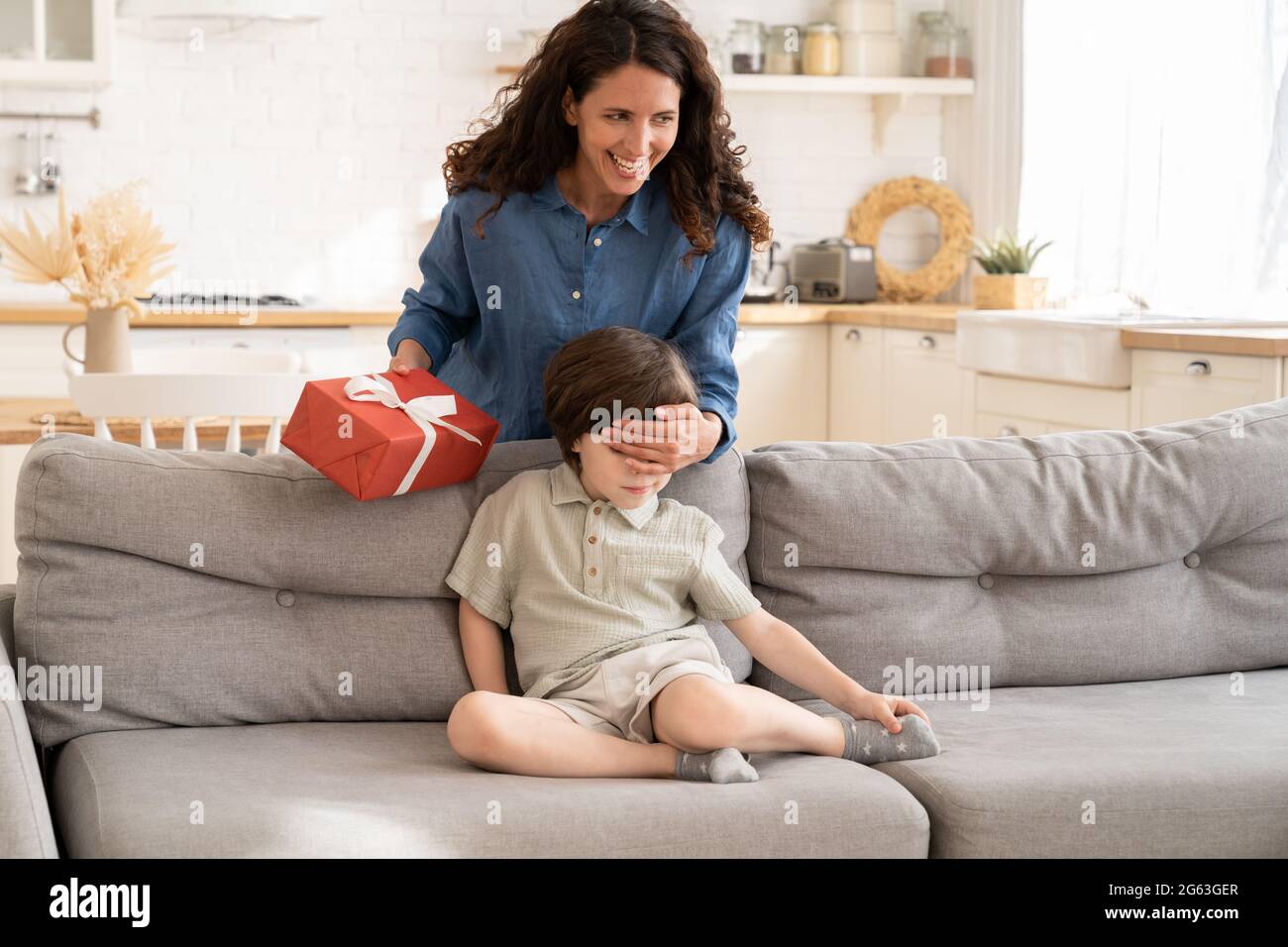 Surprise for son on birthday: caring mom greeting boy cover kid eyes ...