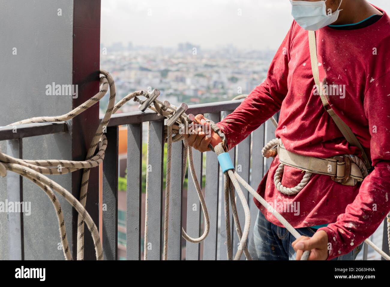 Construction workers holding steel hooks connecting with rope for self ...
